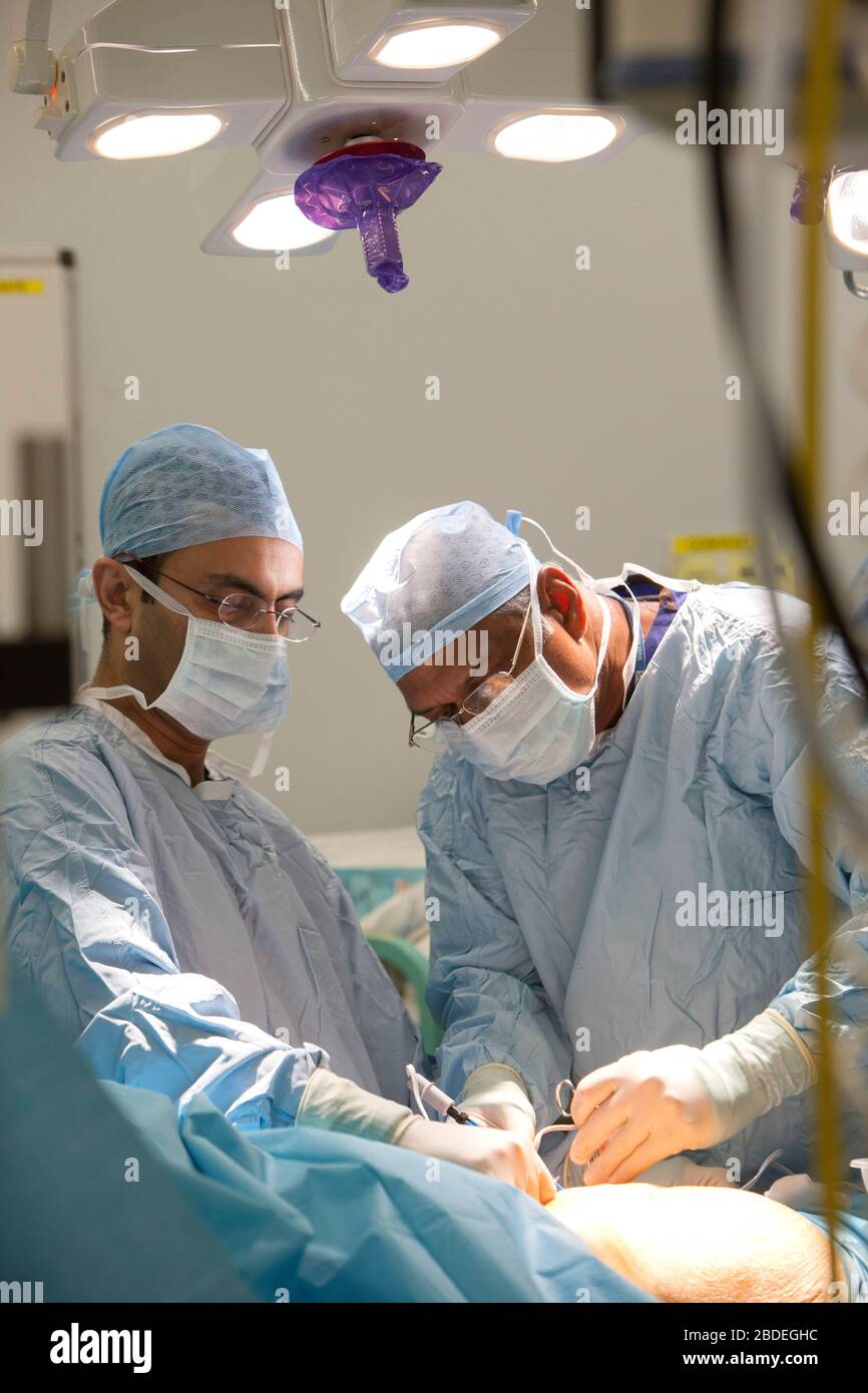 Surgeons and nurses perform stomach surgery in an NHS hospital. The NHS ...