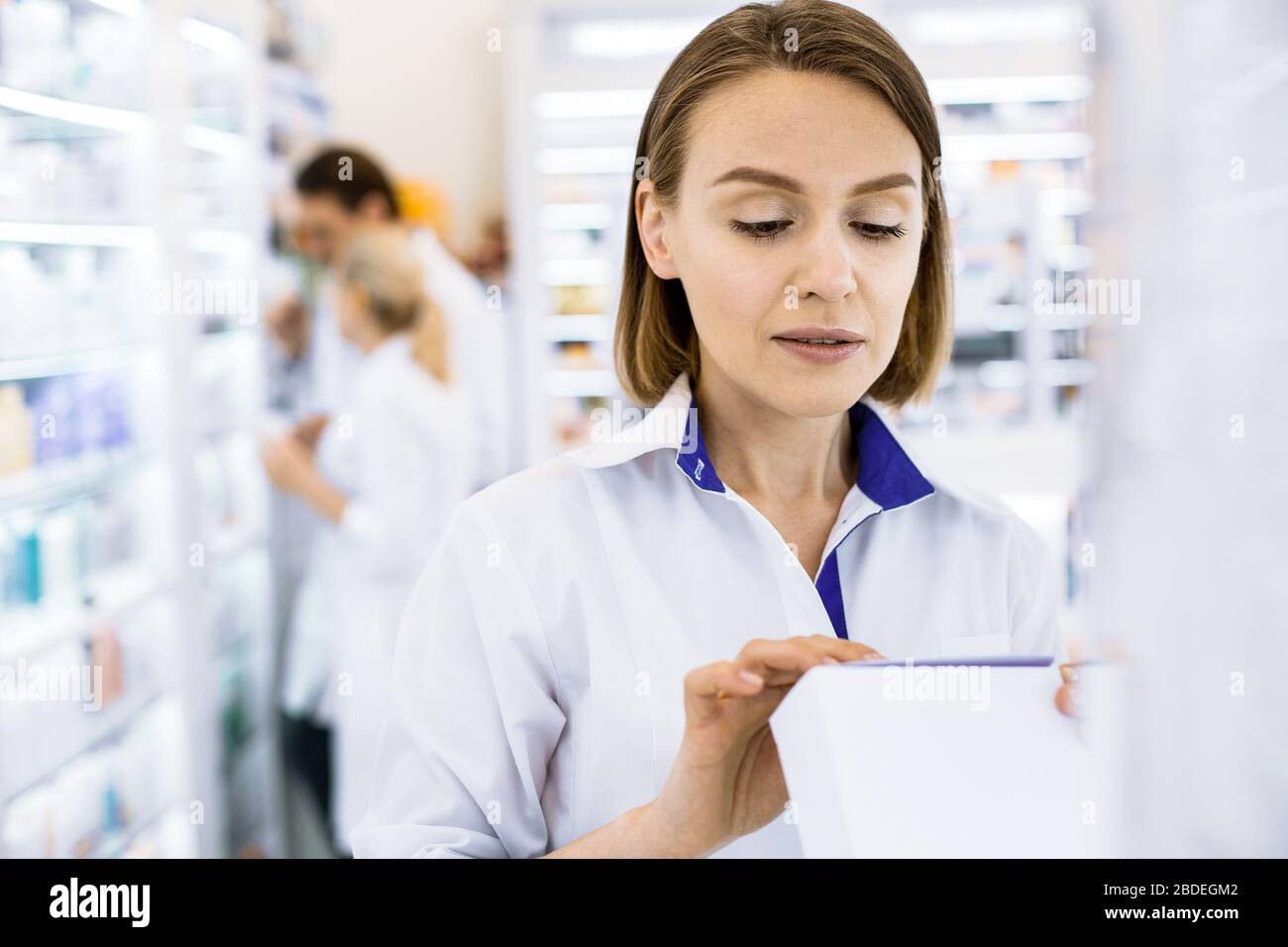 Serious female pharmacist studying the composition of the drug Stock ...