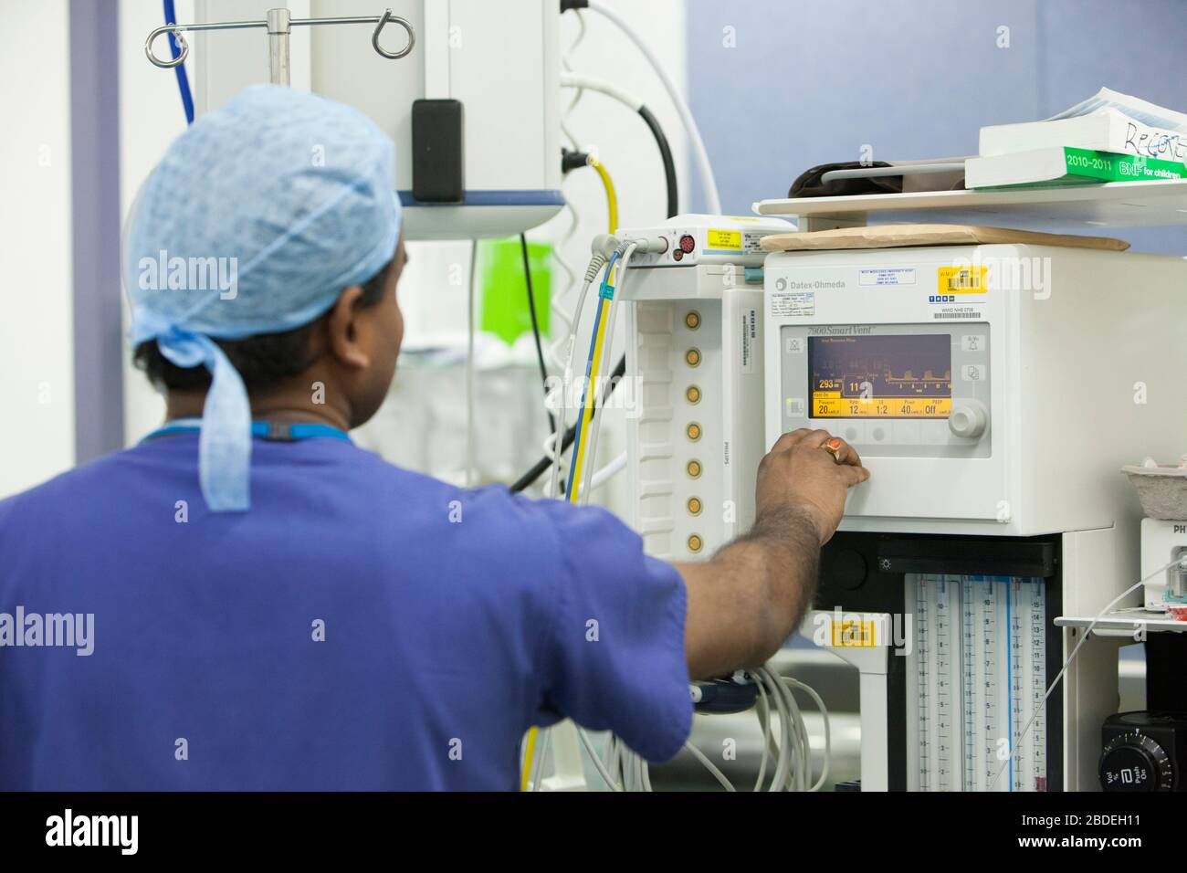 An Anaesthetist in a Hospital Theatre checks on the patient's progress ...