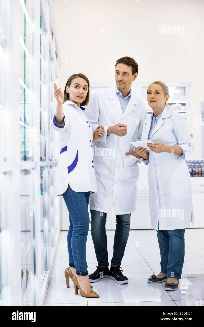 Three ambitious young pharmacists discussing new medication Stock Photo ...