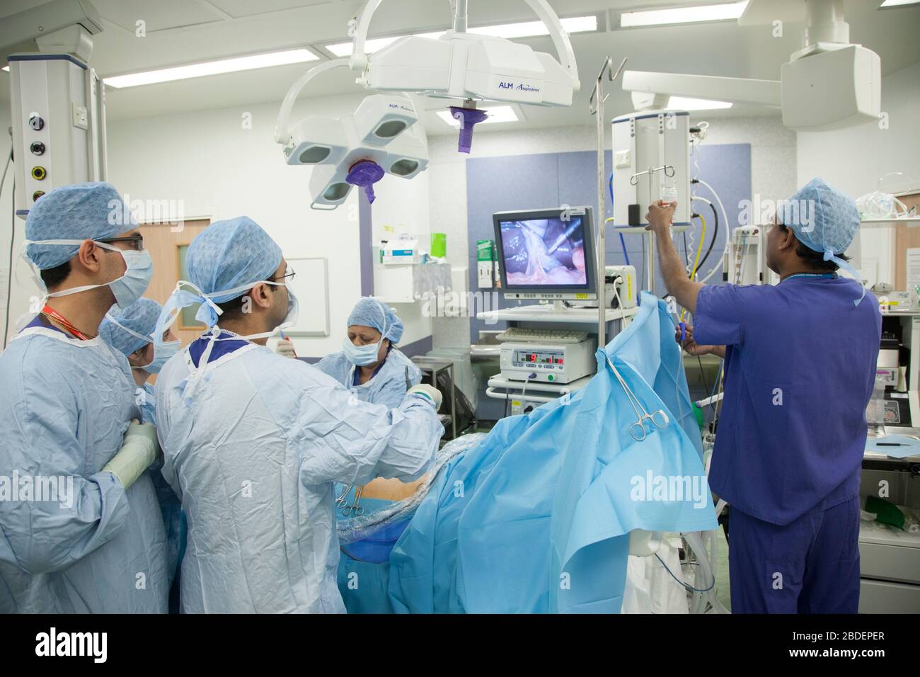 NHS Surgeons perform laparascopic surgery on a patient's stomach while ...