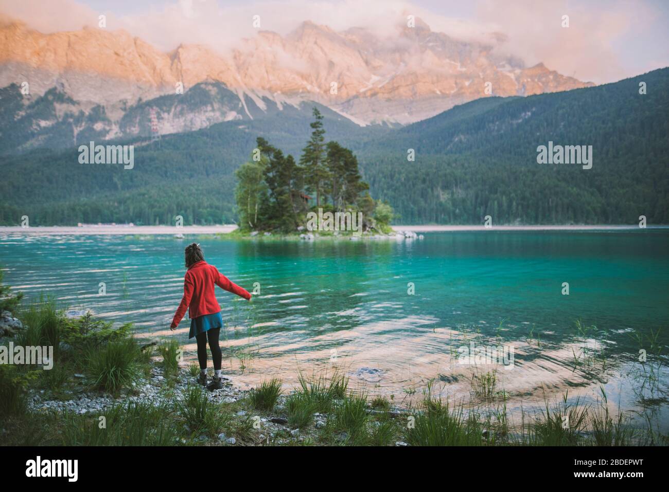 Germany, Bavaria, Eibsee, Young woman walking at shore of Eibsee lake ...