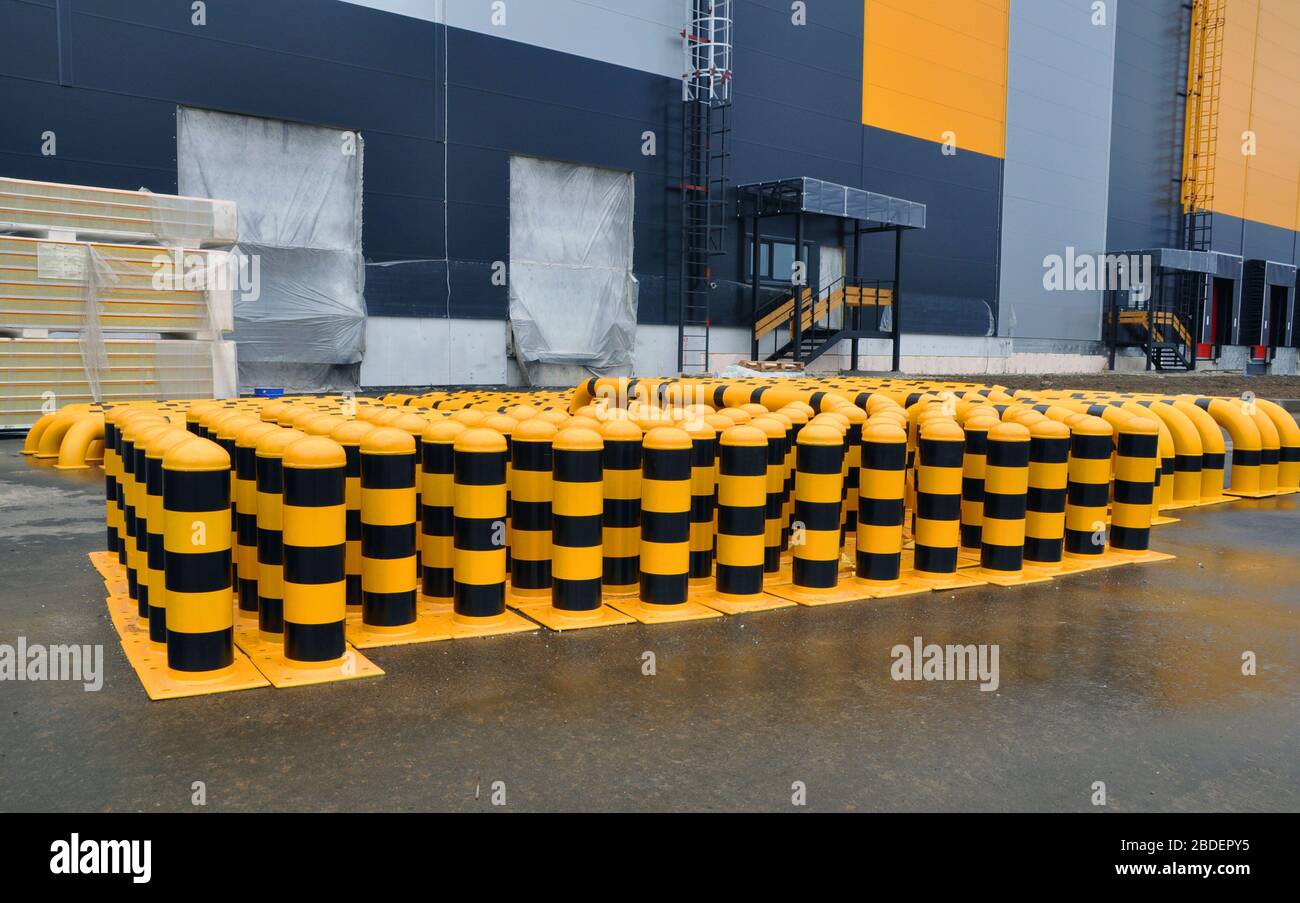 A group of yellow-black road poles on the territory of an industrial ...