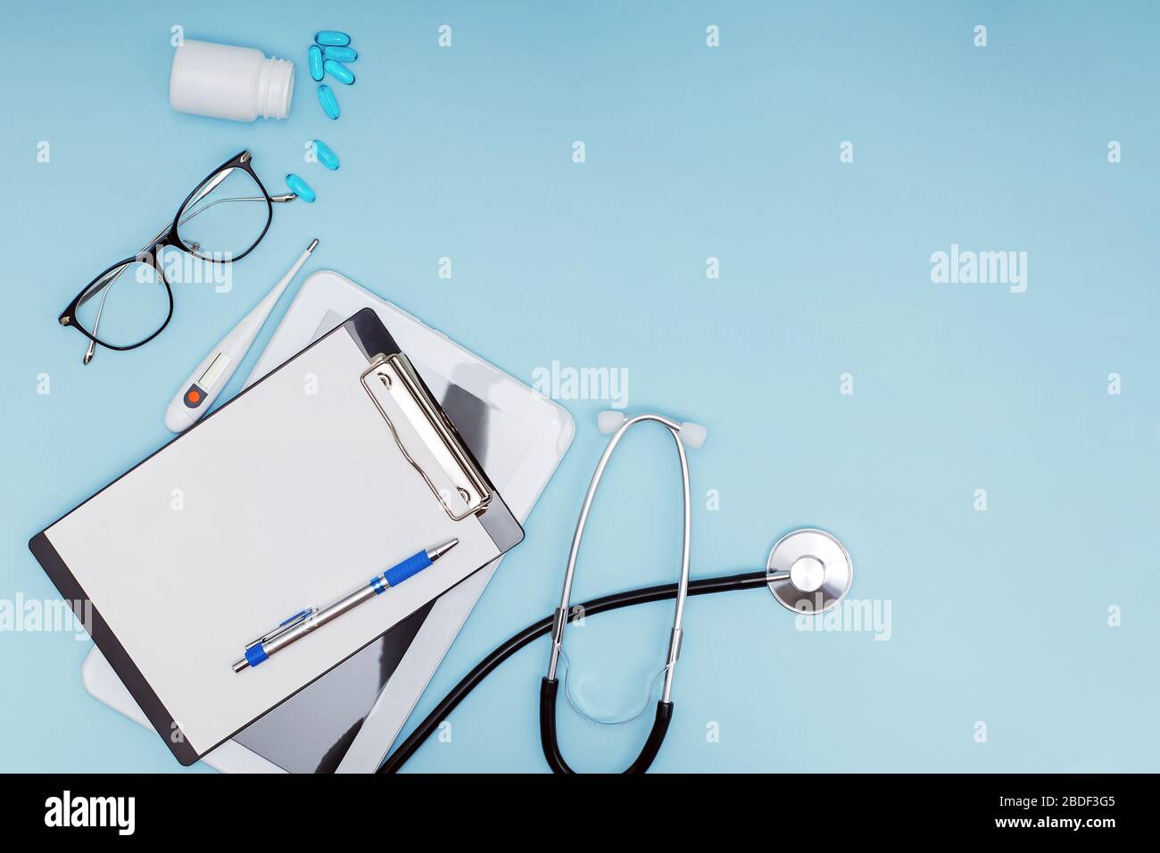 Workplace of modern doctor concept. Tablet, glasses, pills, stethoscope ...