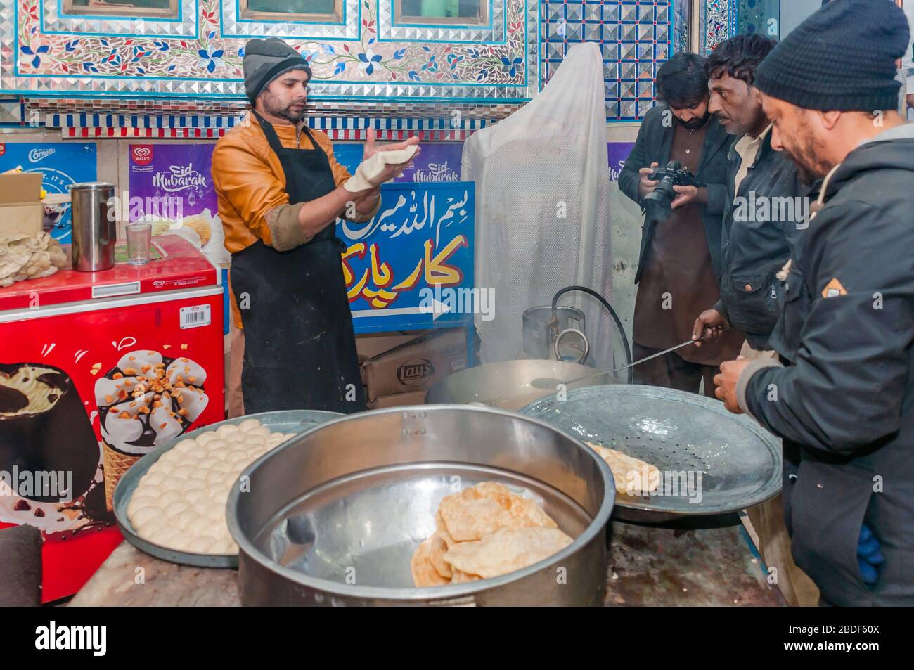 Men prepare Deep fried poori in the kitchen, crispy very popular street ...