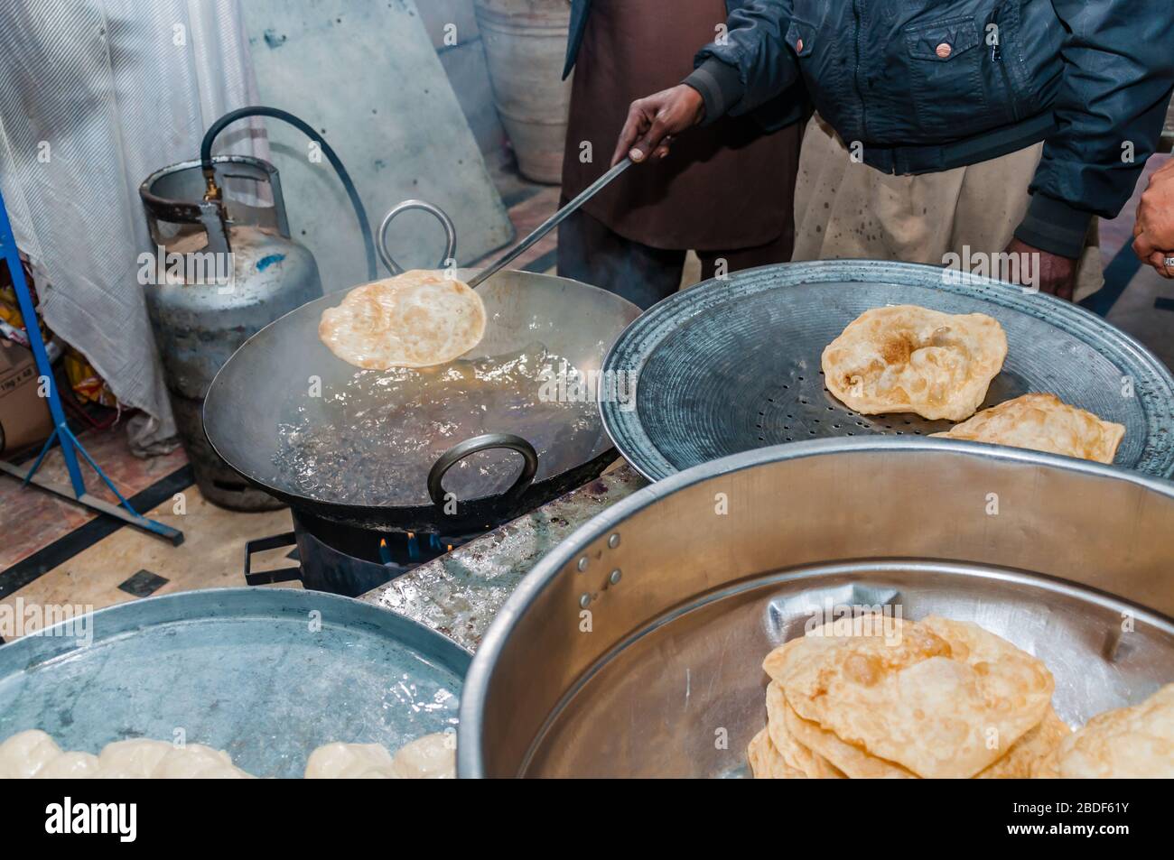 Men prepare Deep fried poori in the kitchen, crispy very popular street ...