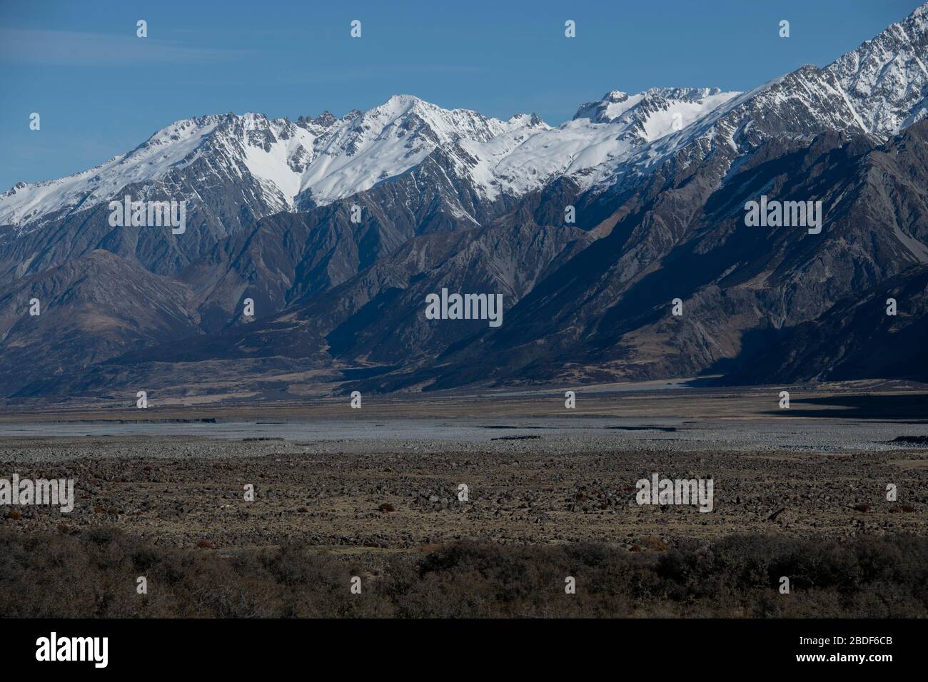 View across outwash plain with snow-capped mountains in background ...