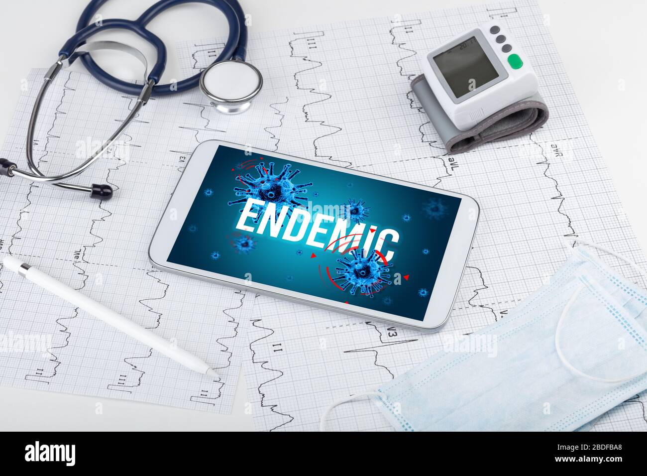 Tablet pc and doctor tools on white surface with ENDEMIC inscription ...