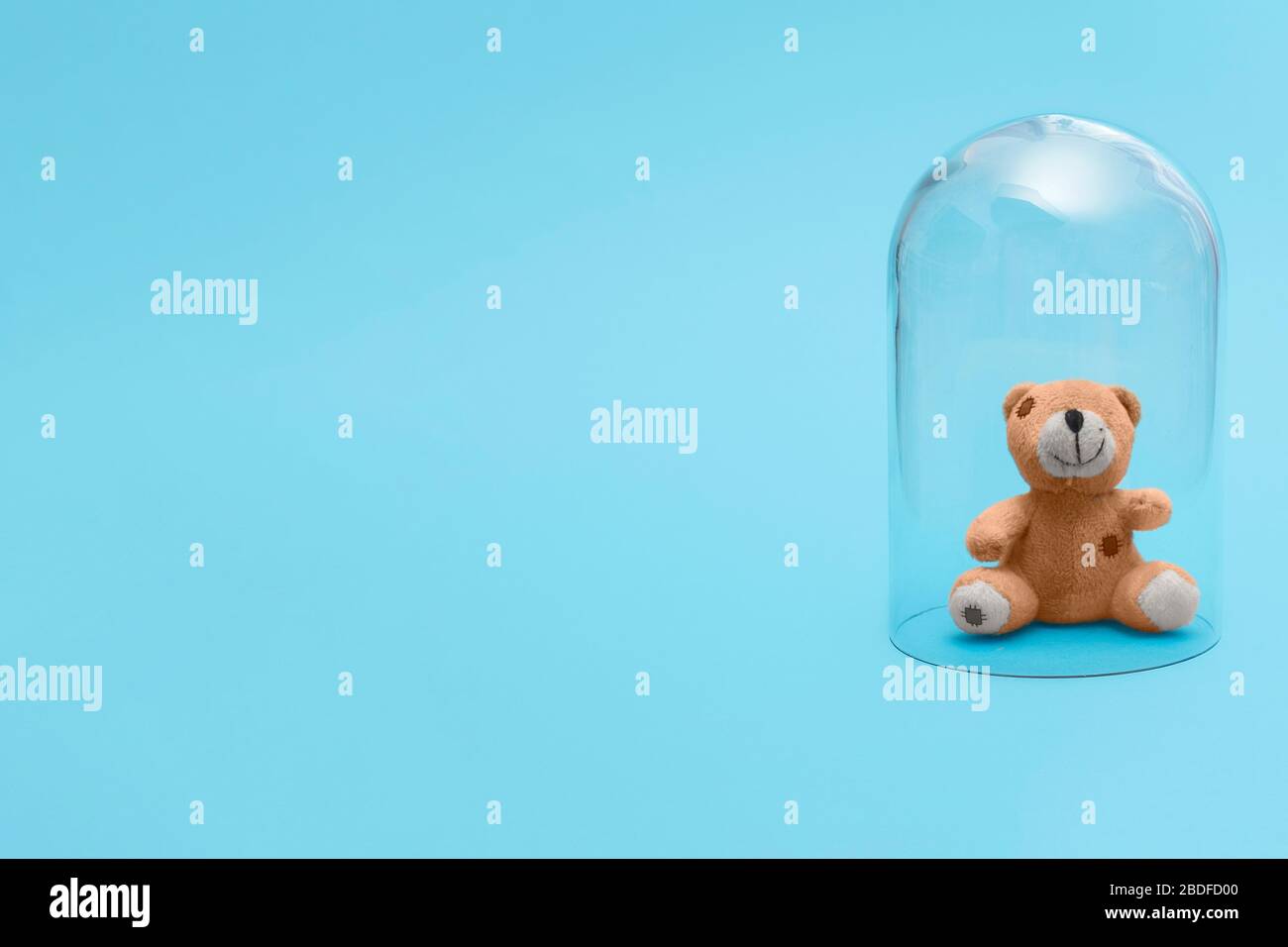 Children kid stuffed cuddly toy bear in quarantine under a glass cloche ...