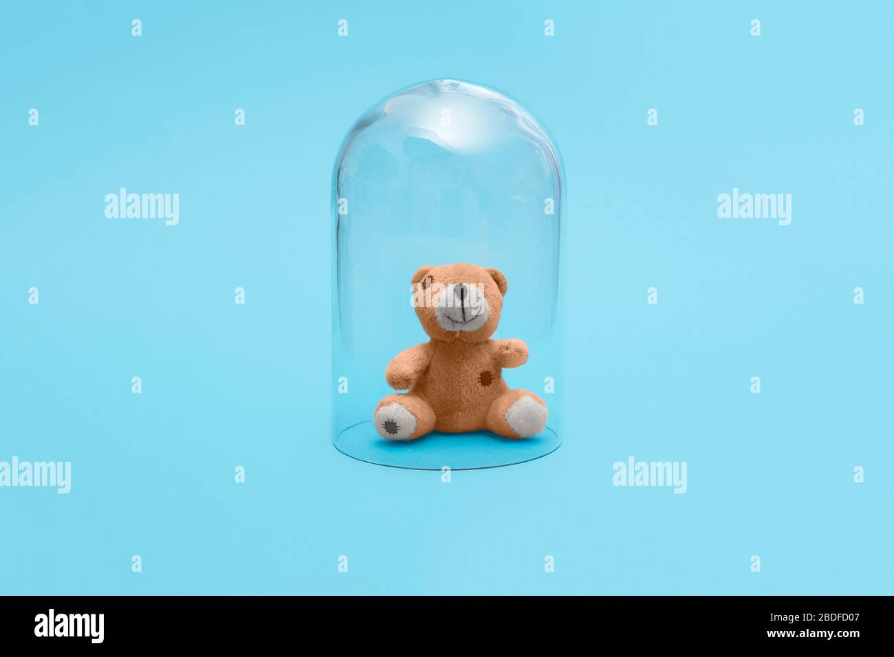 Children kid stuffed cuddly toy bear in quarantine under a glass cloche ...