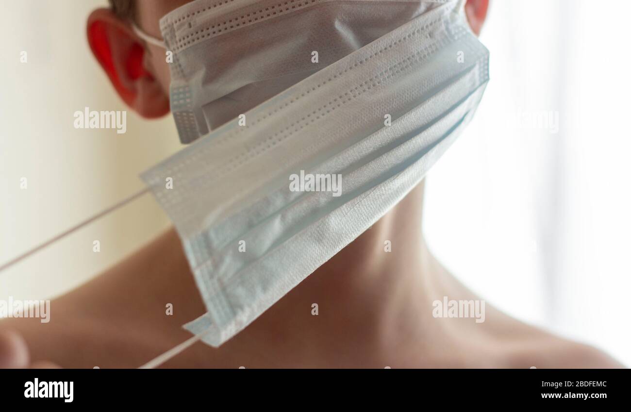 The person in the antiviral mask puts on a second mask for protection ...