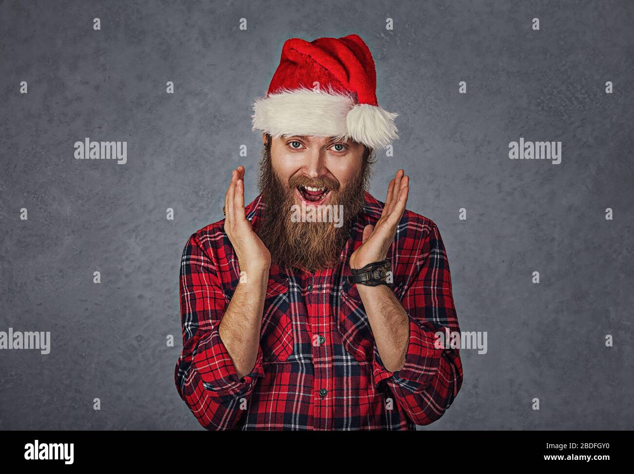 Surprised excited happy bearded man wearing red santa claus hat looking ...