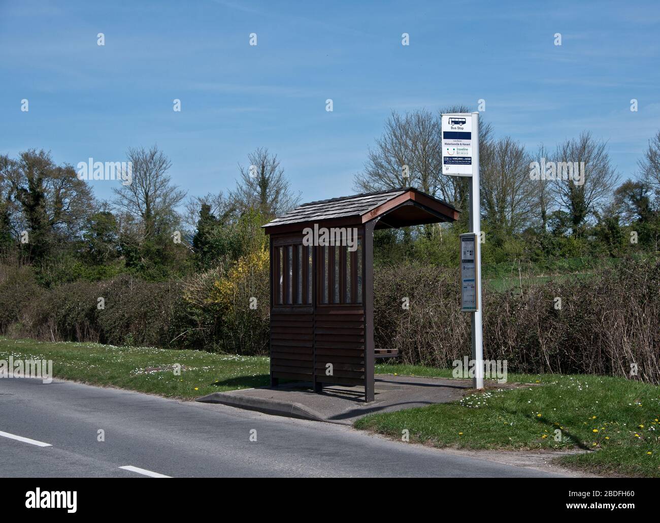 Bus stop with no people and no bus on an empty road. Services much ...