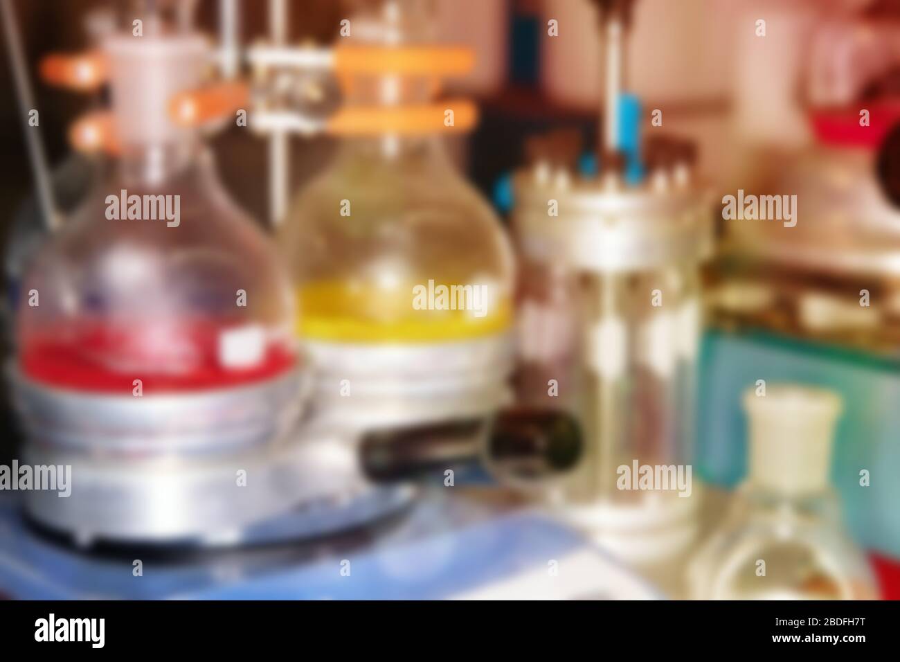 Blurred background of laboratory glass flasks with yellow and red ...
