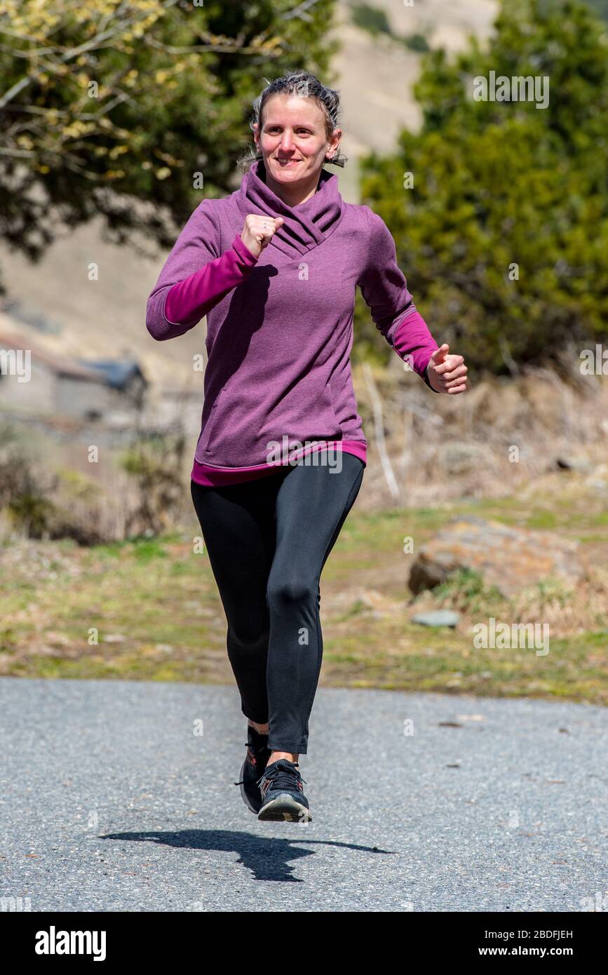 Young woman running up the hill. Trial run Stock Photo - Alamy