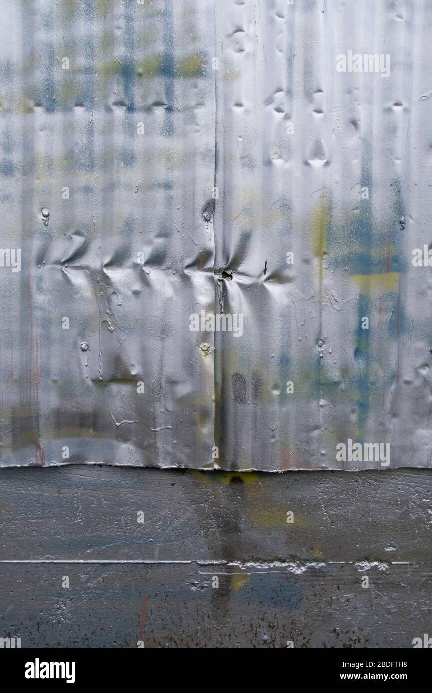 Row of indentation marks on silver spray painted metal wall, close up ...