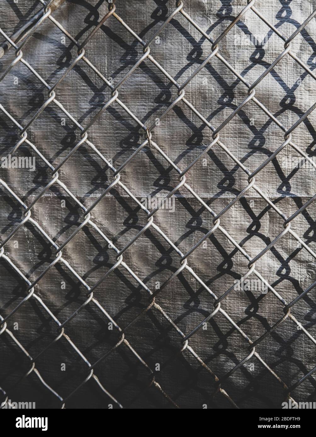 Chain-link fence against metallic tarp Stock Photo - Alamy