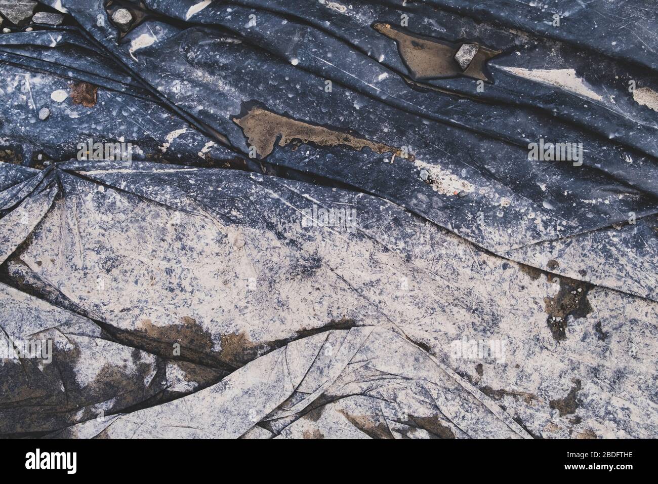 Detail of muddy plastic tarp at construction site Stock Photo - Alamy