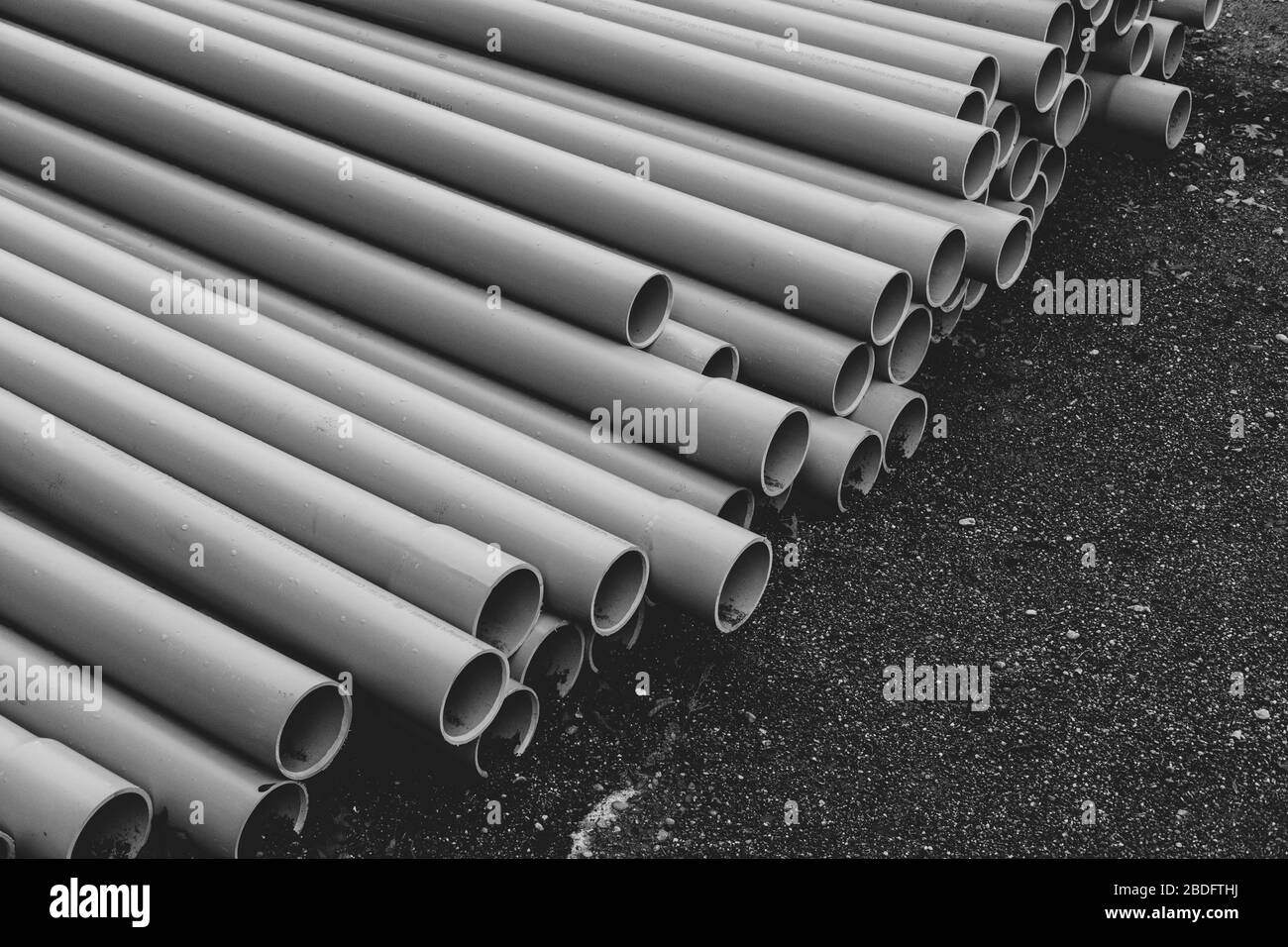 Pile of piping on construction site Stock Photo - Alamy