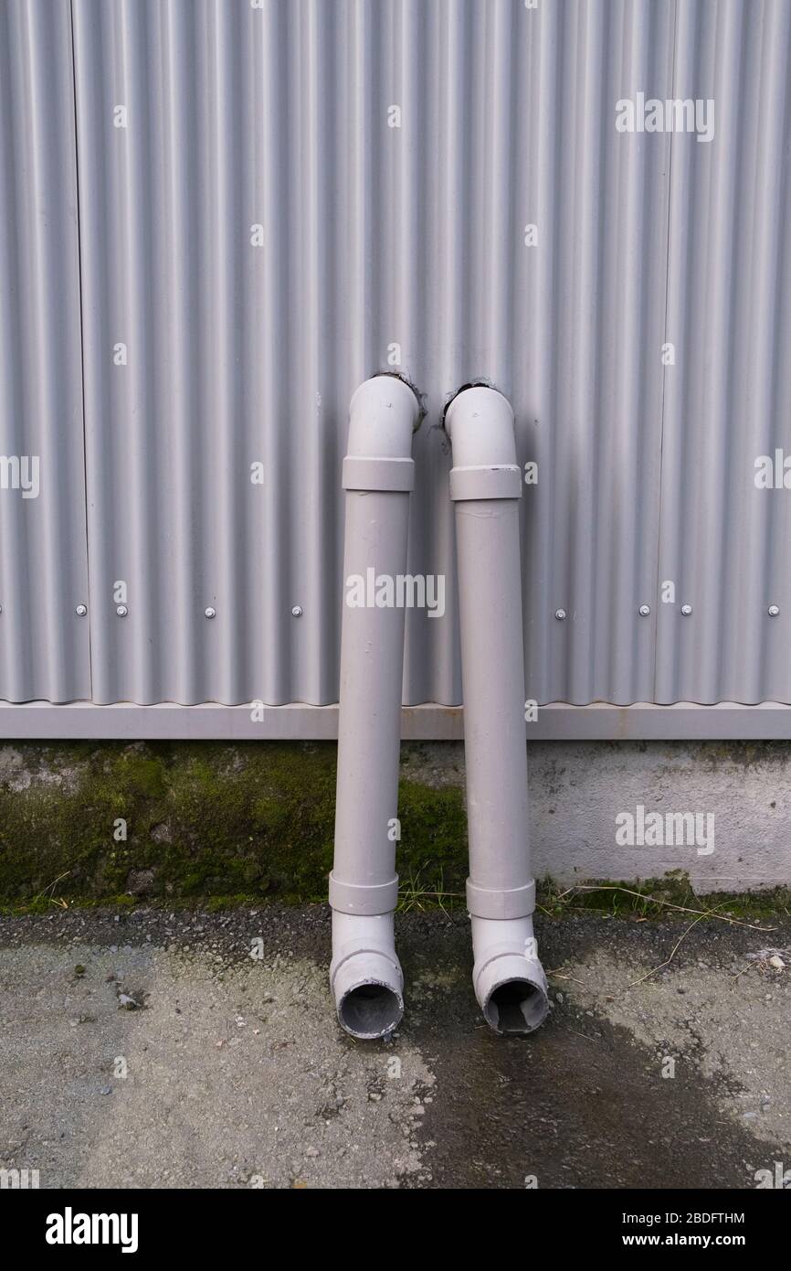 Drain gutter pipes on warehouse exterior wall Stock Photo - Alamy
