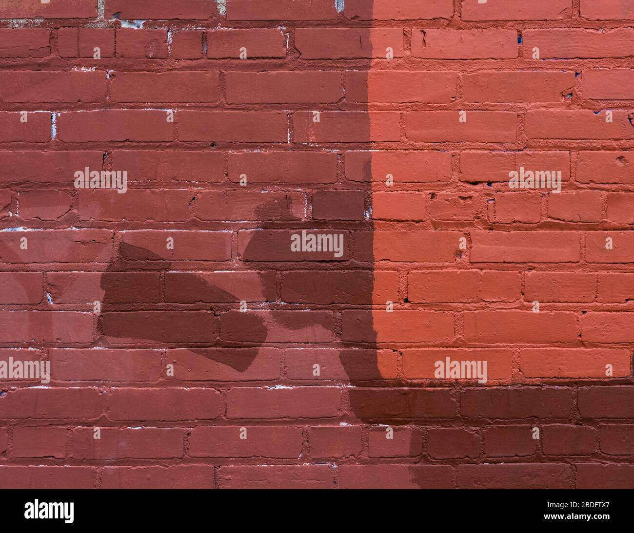 Brown, tan and red paint covering graffiti on old brick wall Stock ...
