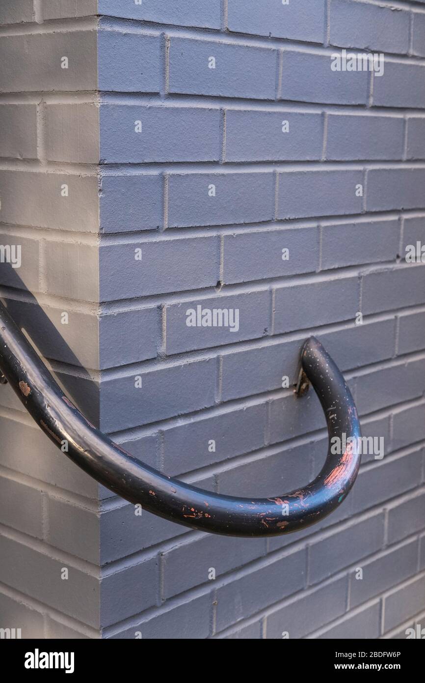 Close up of curved metal handrail attached to a brick wall Stock Photo ...