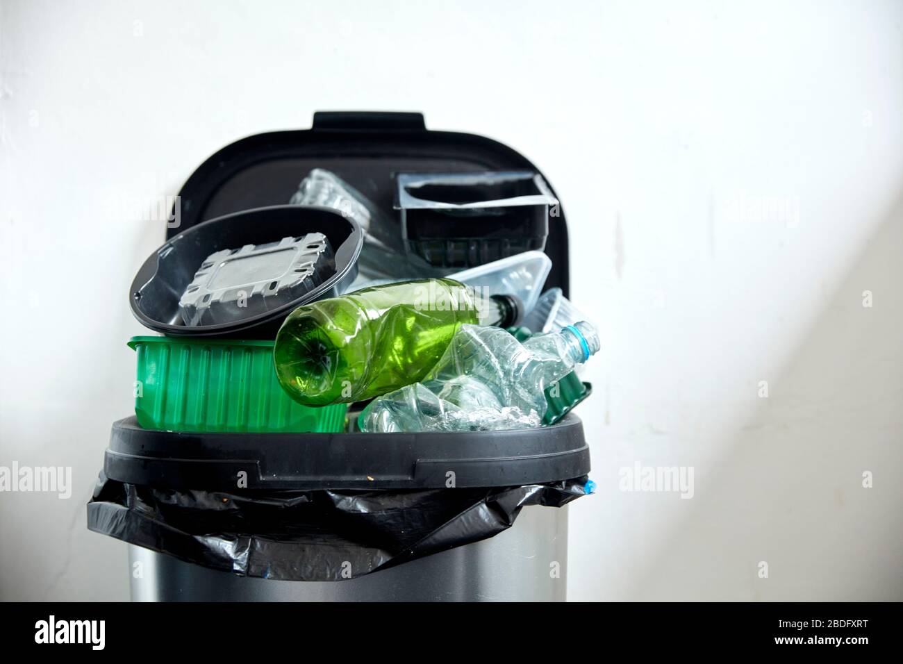 Used plastic containers filling up kitchen dustbin Stock Photo - Alamy