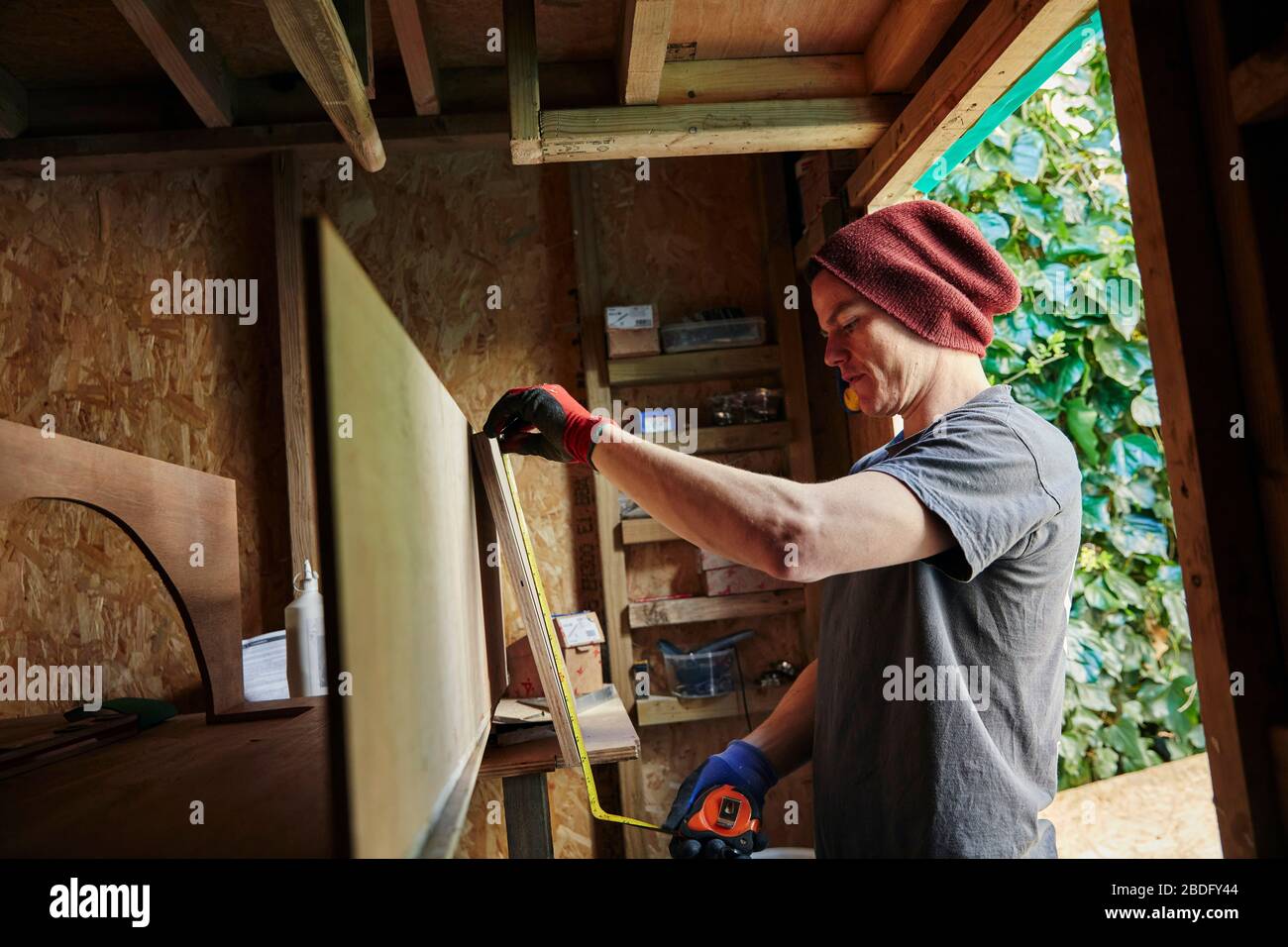 Carpenter using tape measure in shed Stock Photo - Alamy
