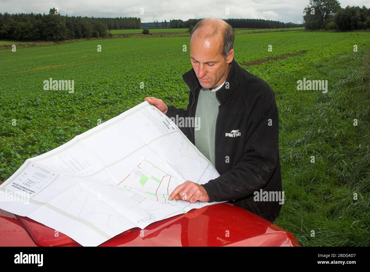 Farmer checking maps of his farm out in the field Stock Photo - Alamy