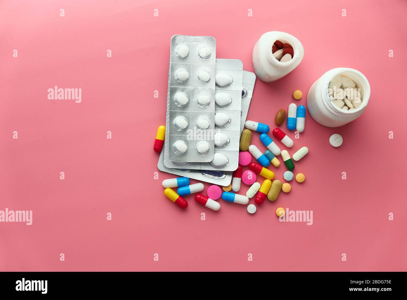 colorful pills, container and blister pack on pink Stock Photo - Alamy