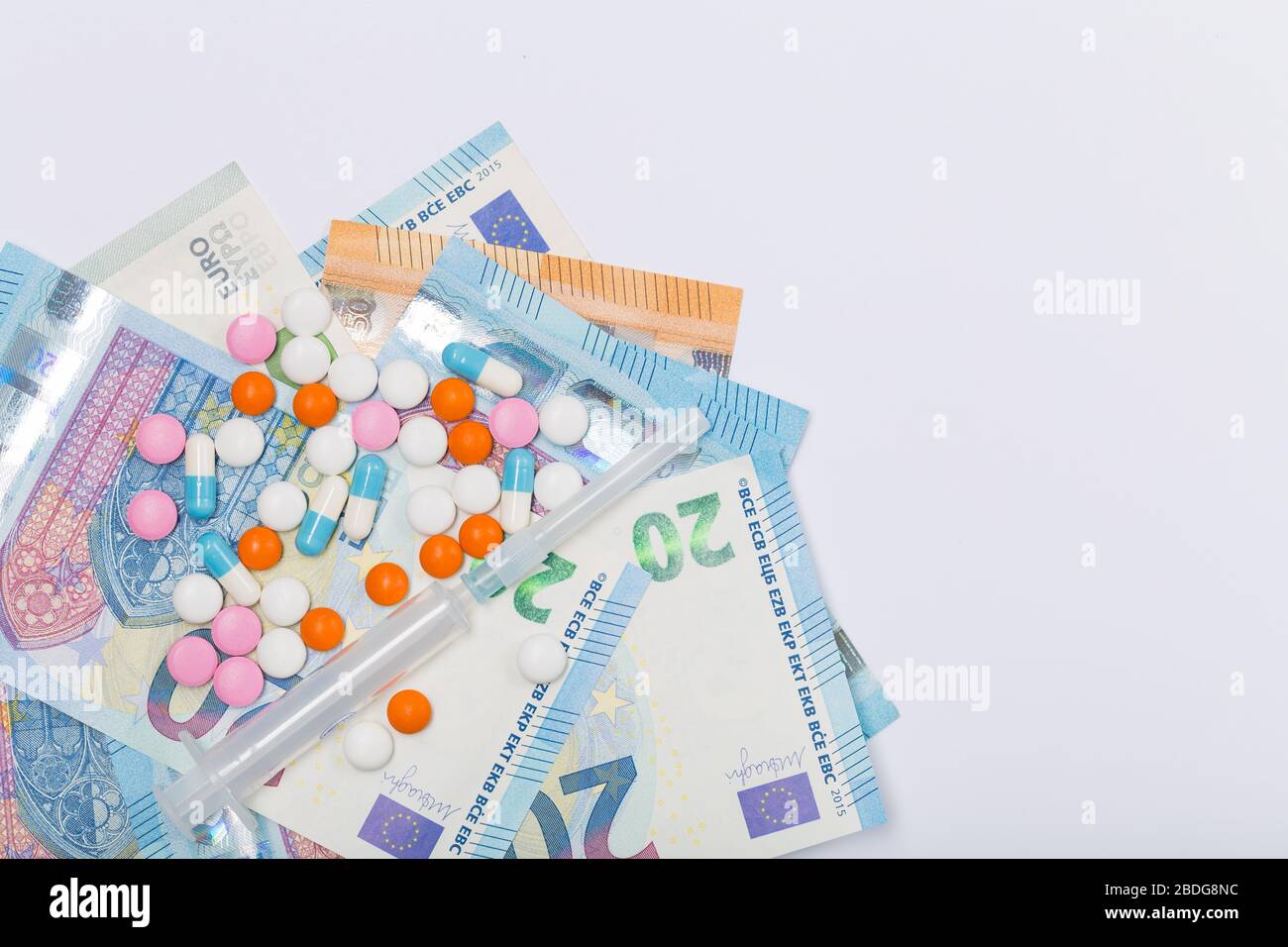 Assorted pharmaceutical medicine pills, tablets and syringe on EU euros ...
