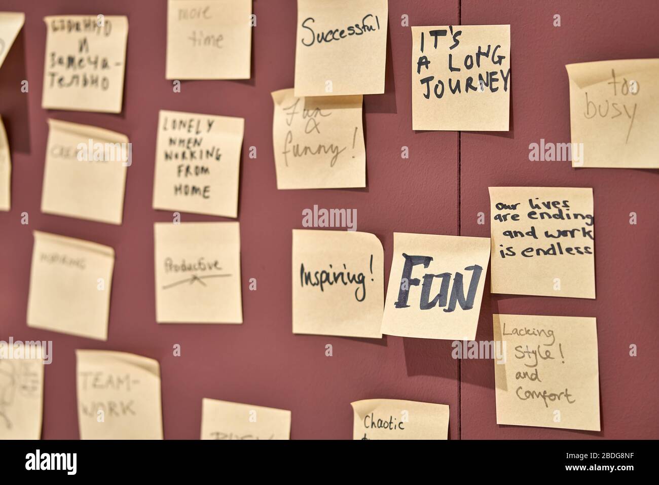 Wine-red wall with hanging yellow sticky notes Stock Photo - Alamy
