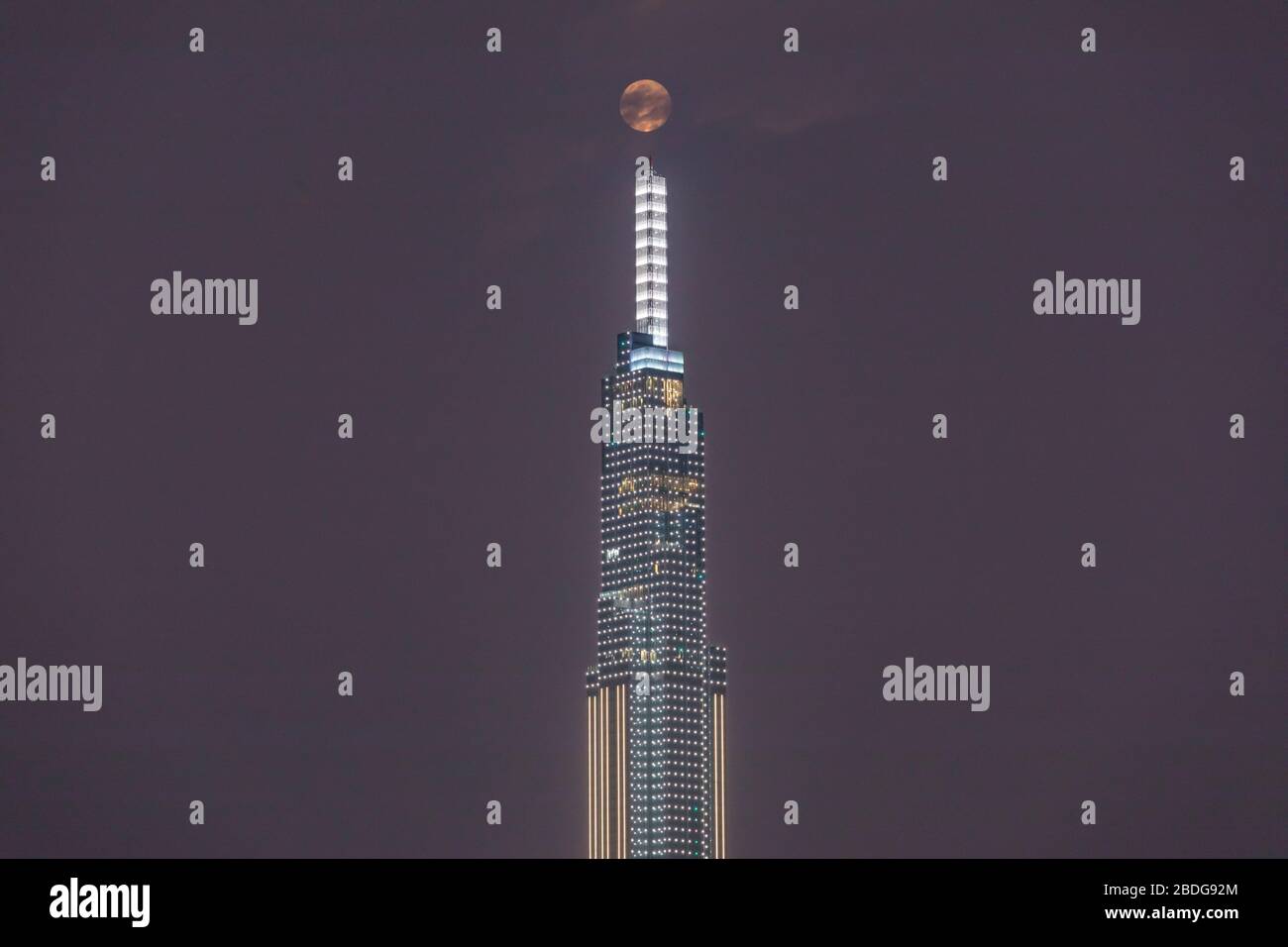 Glowing full Gibbons moon rising alongside the Landmark high rise ...