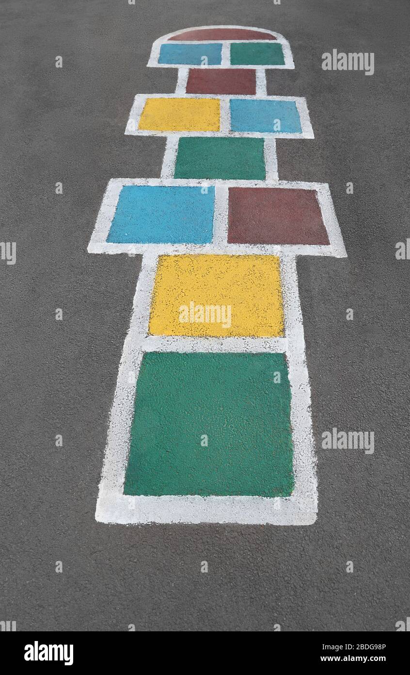 Hopscotch game being drawn with a colorful paint on the asphalt ground ...