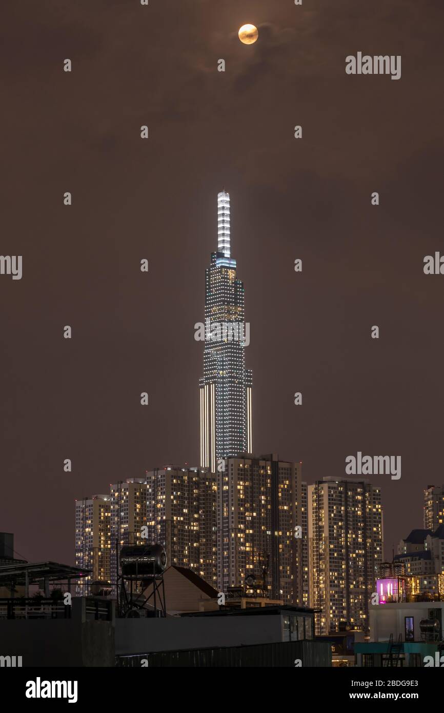 Glowing full Gibbons moon high in the sky with landmark high rise ...