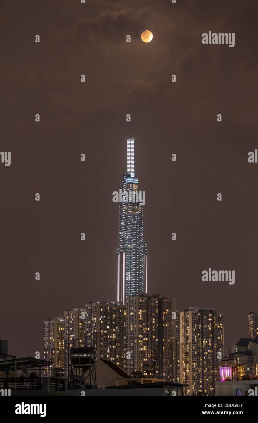 Glowing full Gibbons moon high in the sky with landmark high rise ...