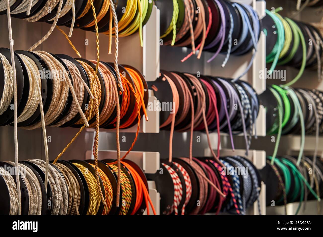 Stand with coils of multicolored textile braided cables Stock Photo - Alamy