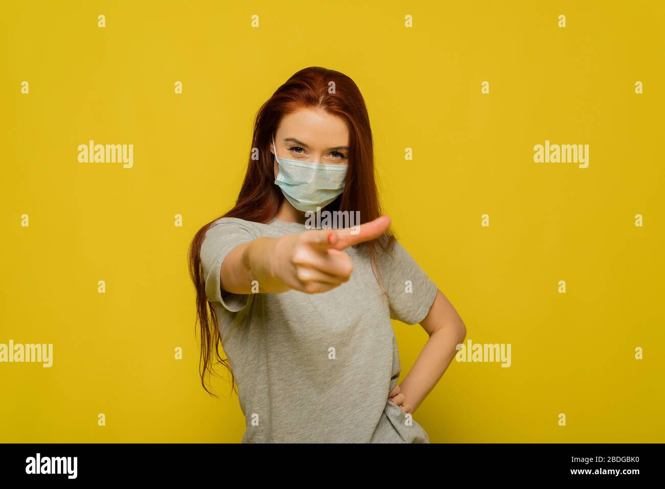 A portrait of young anxious woman in panic in facial protective mask ...