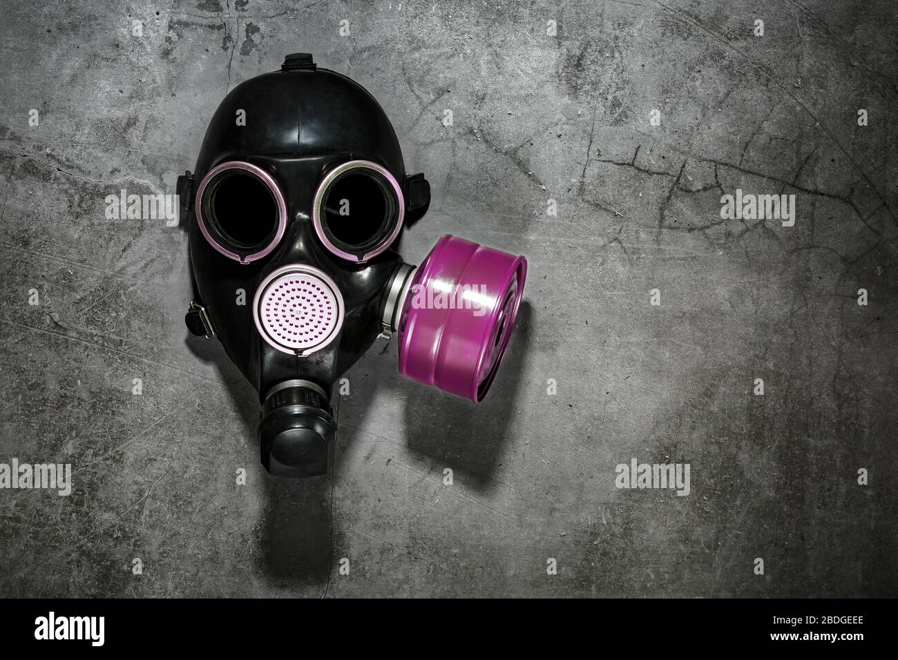 Gas mask on a black stone background with a pink filter cartridge. Post ...