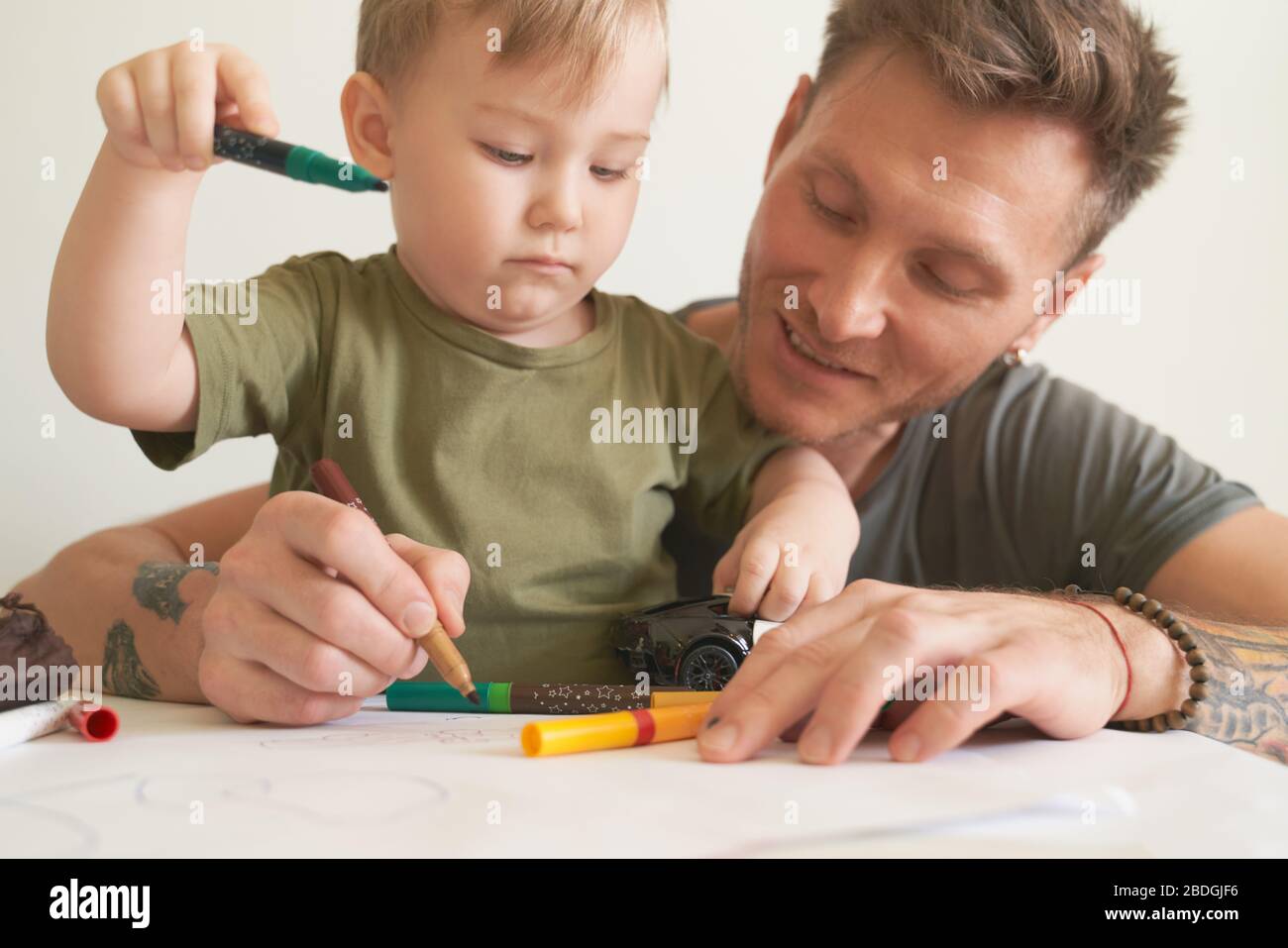 Young father helps son at age of two draw, teaches Stock Photo - Alamy