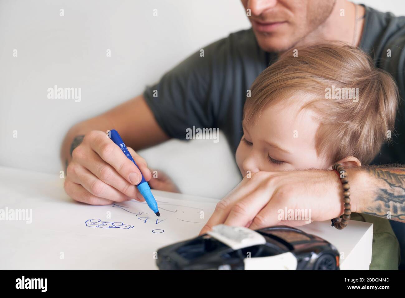 Young father helps son at age of two draw, teaches Stock Photo - Alamy