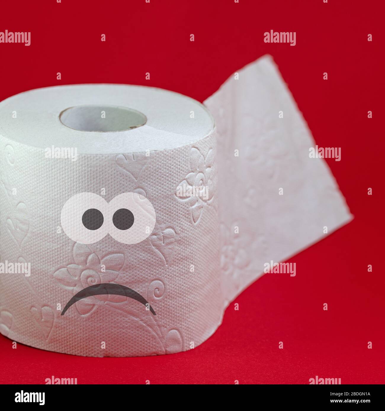 Toilet paper with angry face against red background Stock Photo - Alamy
