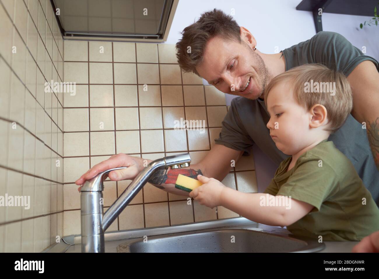 Small child with interest helps man around house Stock Photo - Alamy