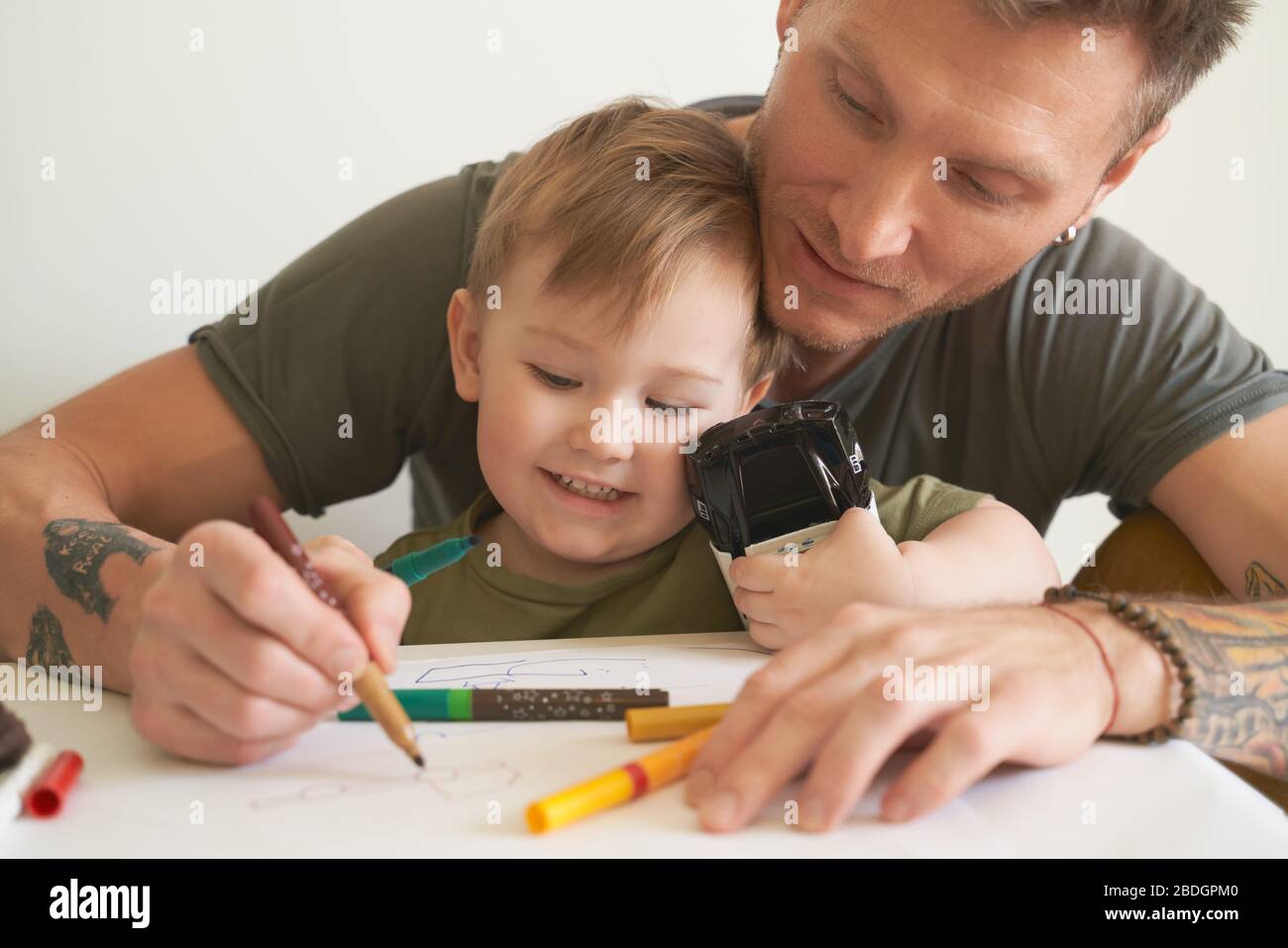 Young father helps son at age of two draw, teaches Stock Photo - Alamy
