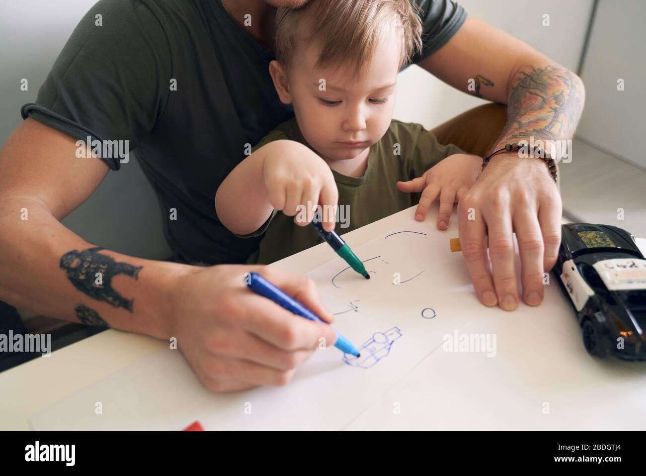 Young father helps son at age of two draw, teaches Stock Photo - Alamy