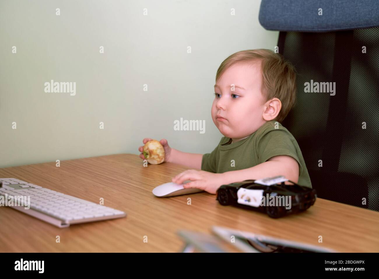 Small child is busily using computer, using mouse Stock Photo - Alamy