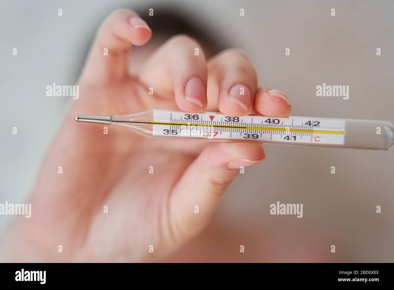Girl holds a thermometer. High body temperature on a thermometer Stock ...
