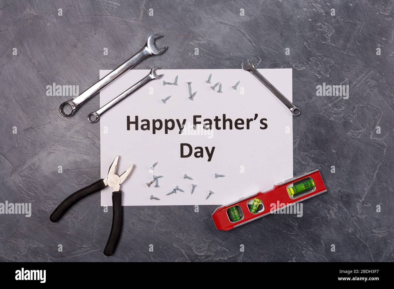 Happy father's day picture frame on black desk with pliers, screw ...