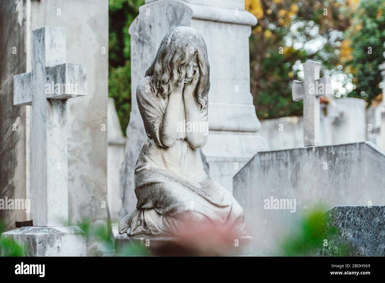 sculpture of a angel girl in an old cemetery. Closeup of stoned angel ...