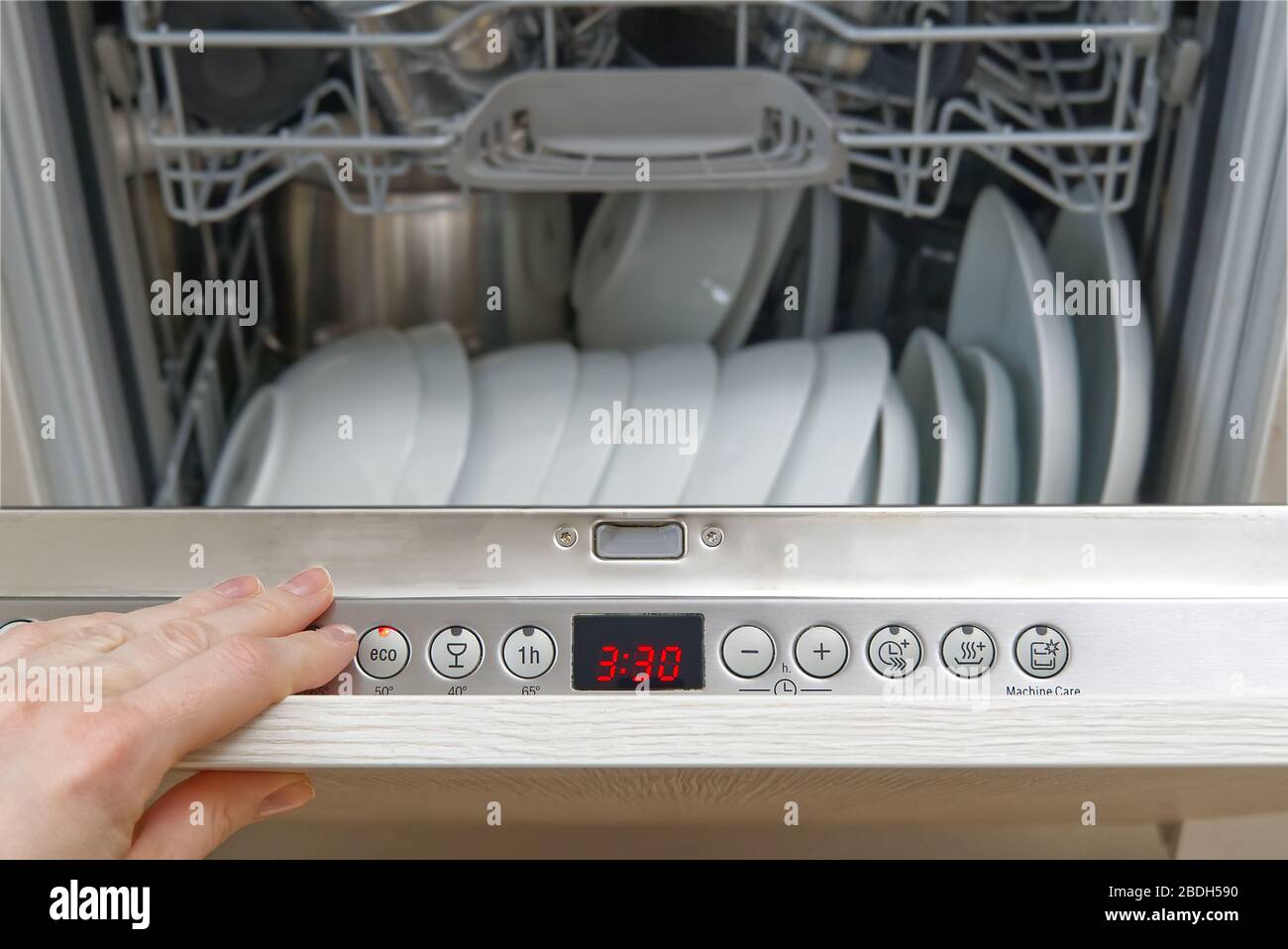 Full loaded Dishwasher machine. Integrated Dishwasher with white plates ...